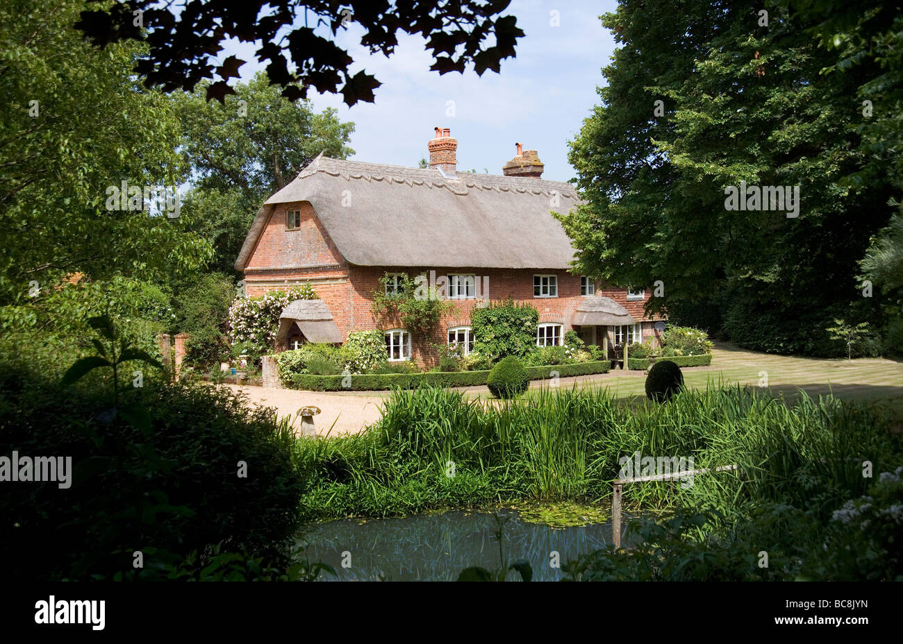 Pretty Period Thatched Cottage with Pond Stock Photo - Alamy