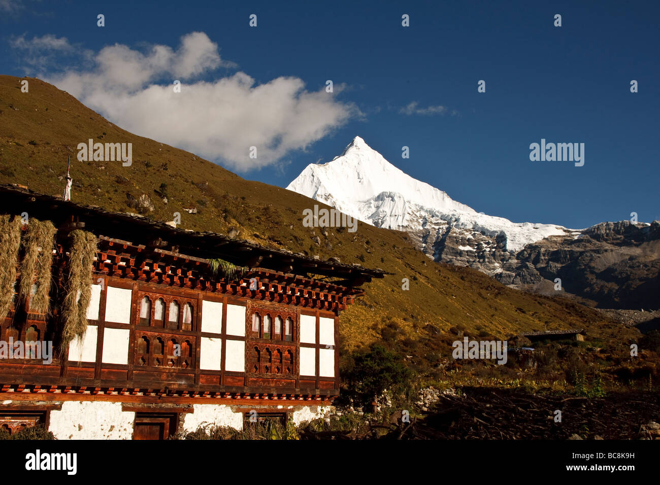 A traditional bhutanese home with Mount Jitchu Drake in the distance ...