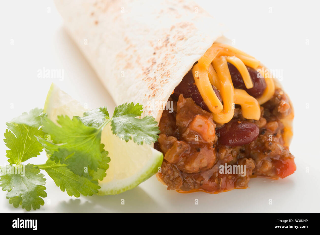 Burrito with chili con carne and cheese, lime, coriander Stock Photo ...