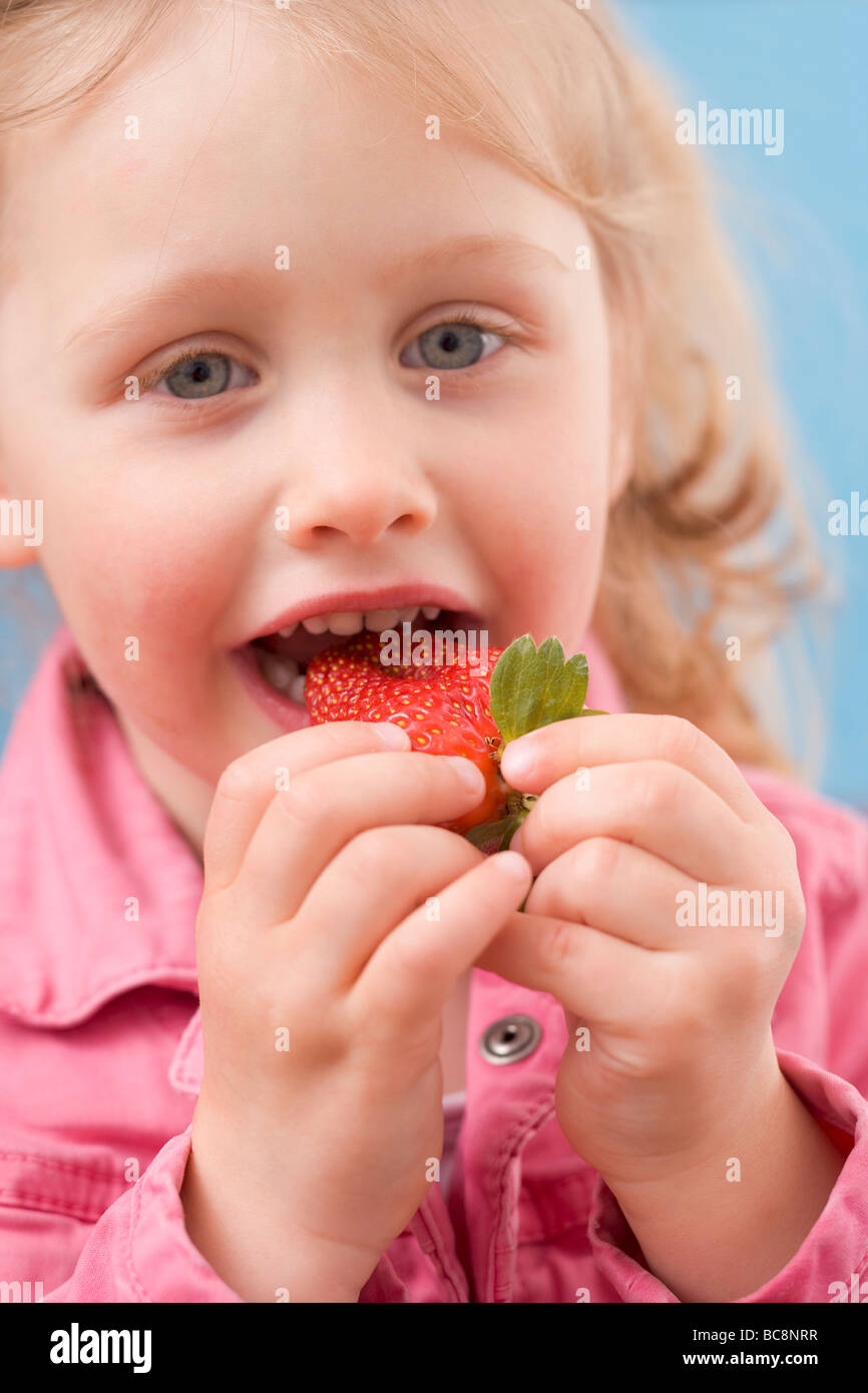 Little girl eating strawberry Stock Photo - Alamy