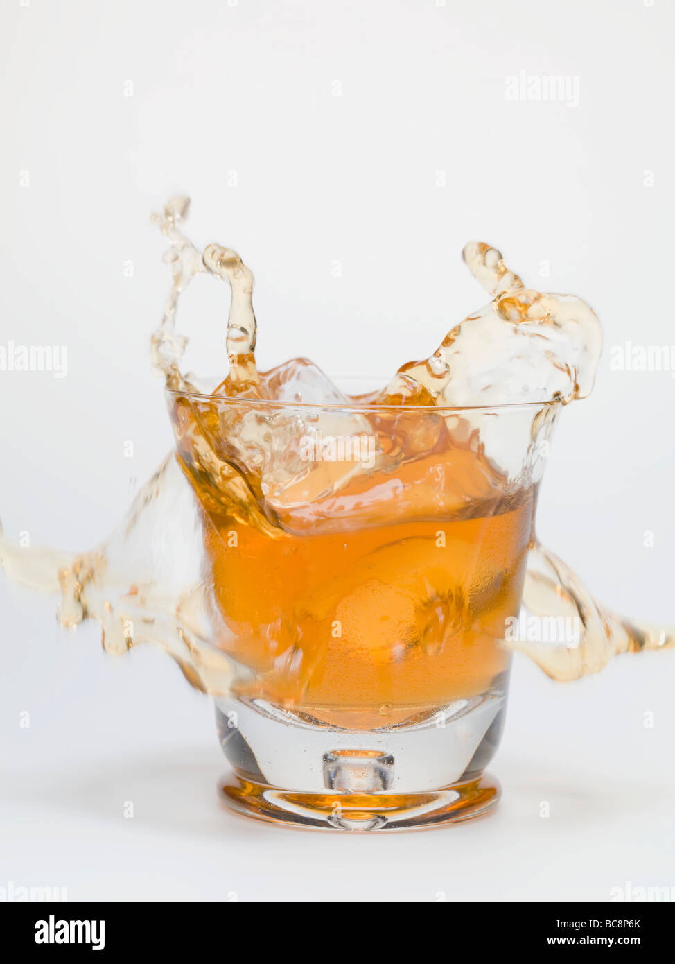 Ice cube falling into a glass of iced tea Stock Photo - Alamy