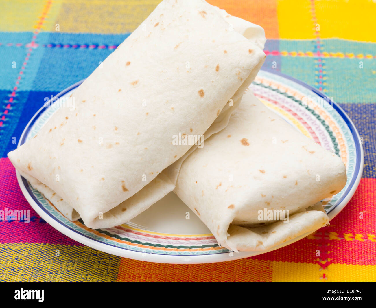 Two tortilla parcels on plate Stock Photo - Alamy