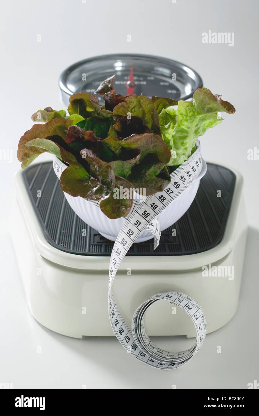 Bowl of lettuce with tape measure on scales Stock Photo - Alamy