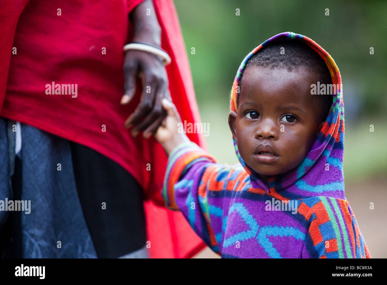 Portrait of a young African boy holding his mother's hand. Kikwe ...