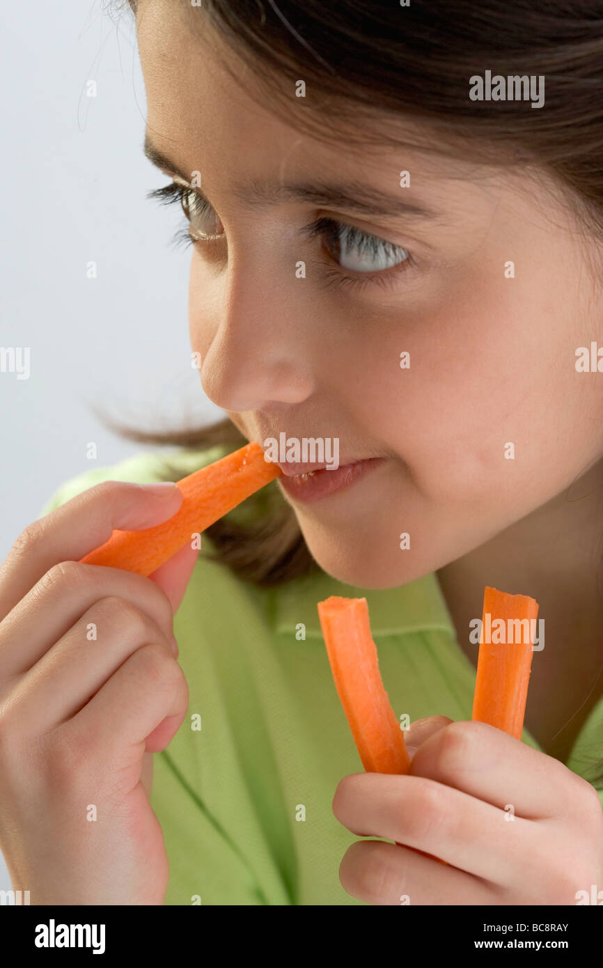 Little girl eating carrot sticks Stock Photo - Alamy
