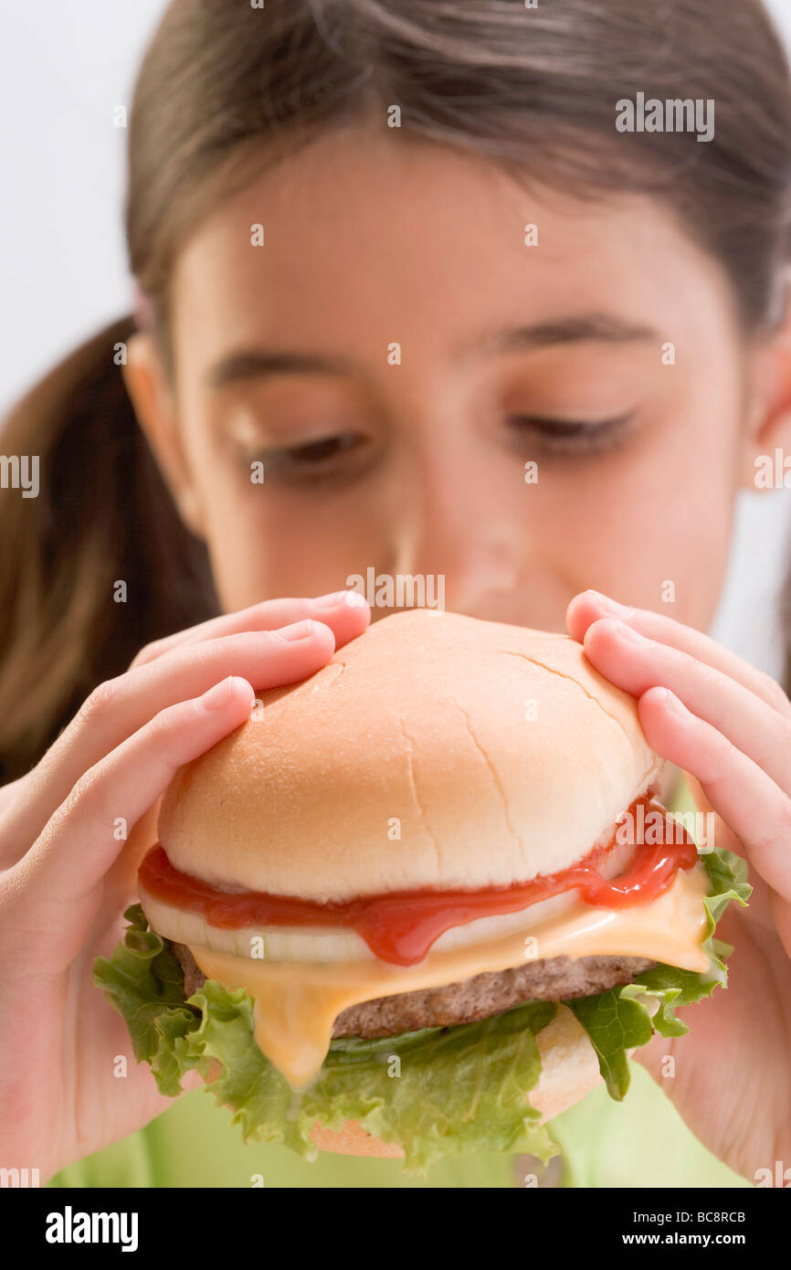 Little girl eating cheeseburger Stock Photo - Alamy