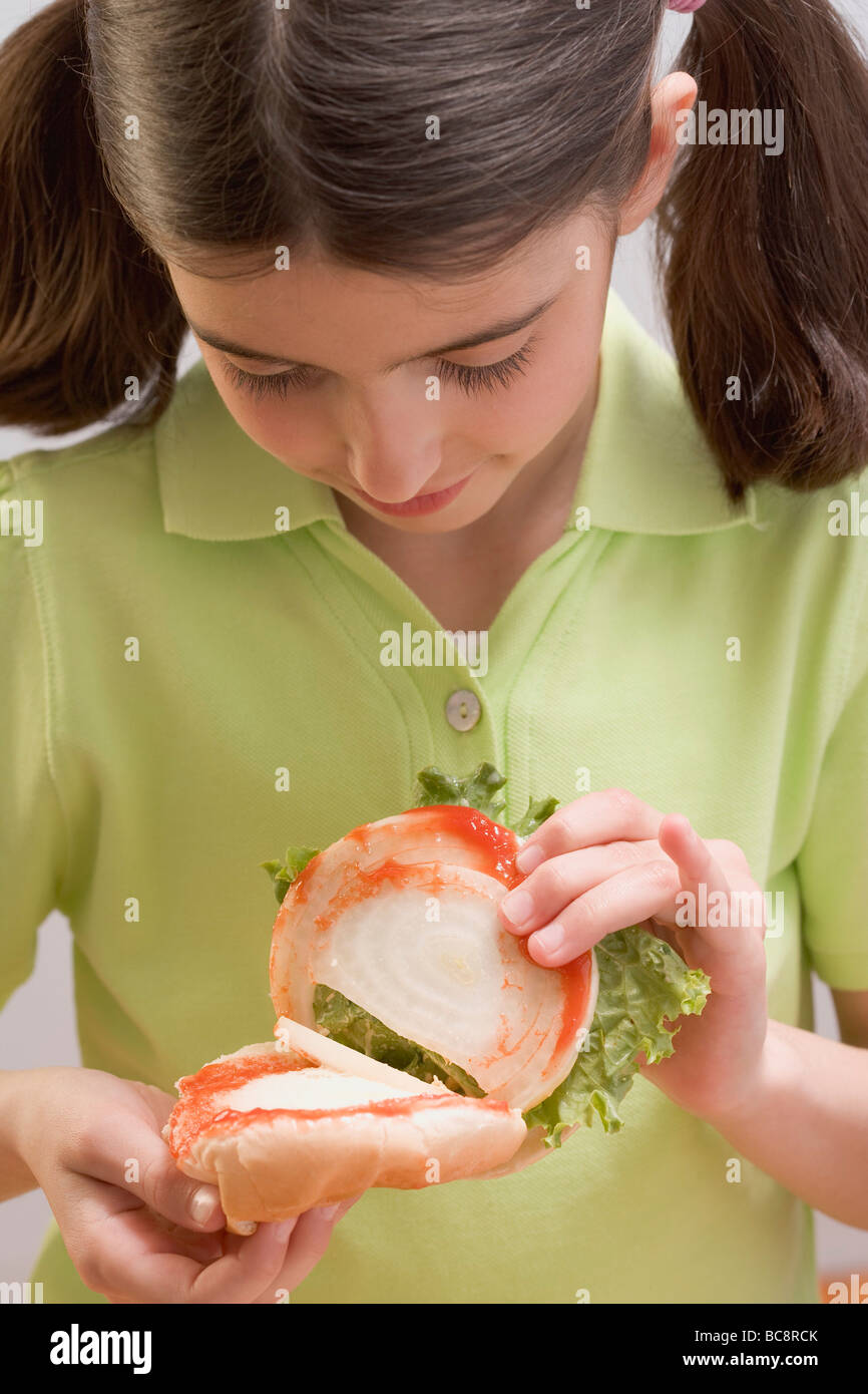 Little girl looking into opened burger Stock Photo - Alamy