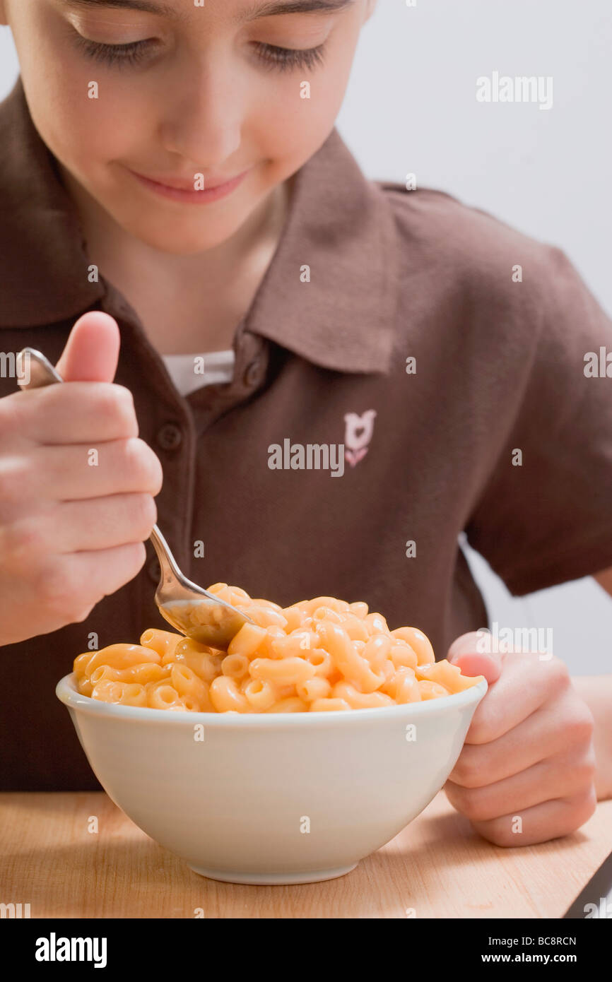 Little girl eating macaroni cheese Stock Photo - Alamy
