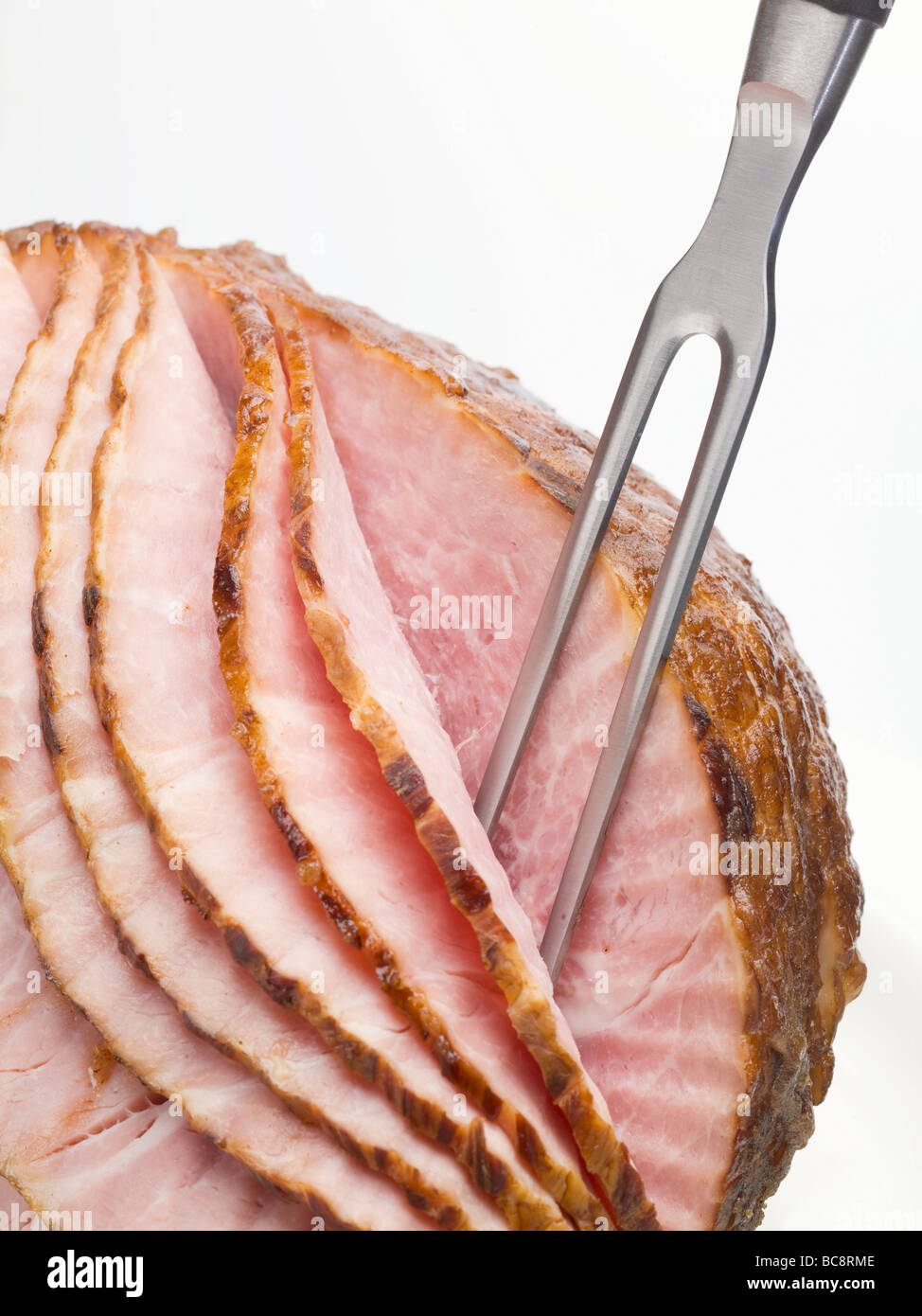 Roast ham, partly carved, with carving fork Stock Photo - Alamy