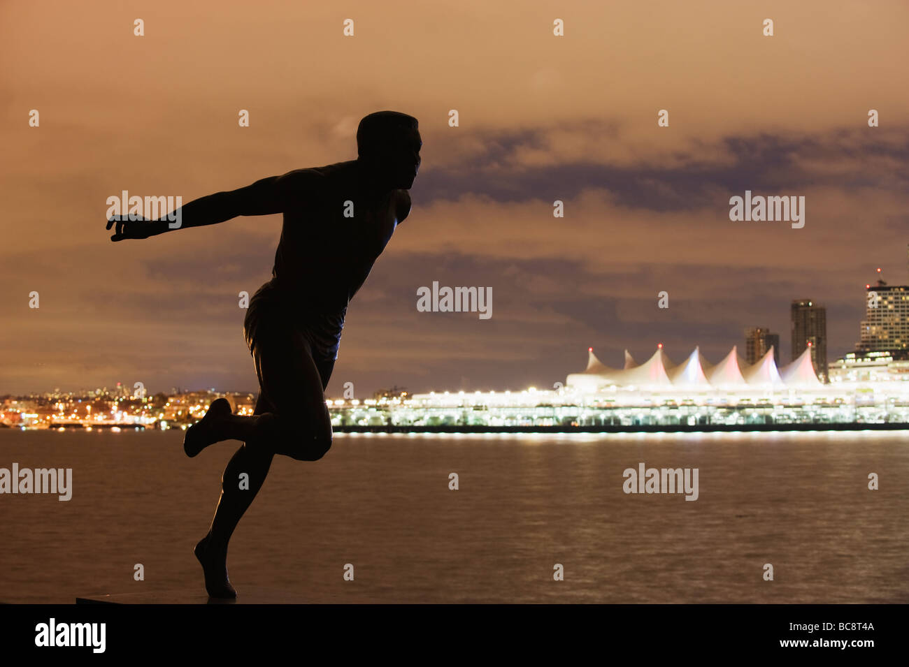 statue of world record runner Harry Jerome silhoutted against city ...