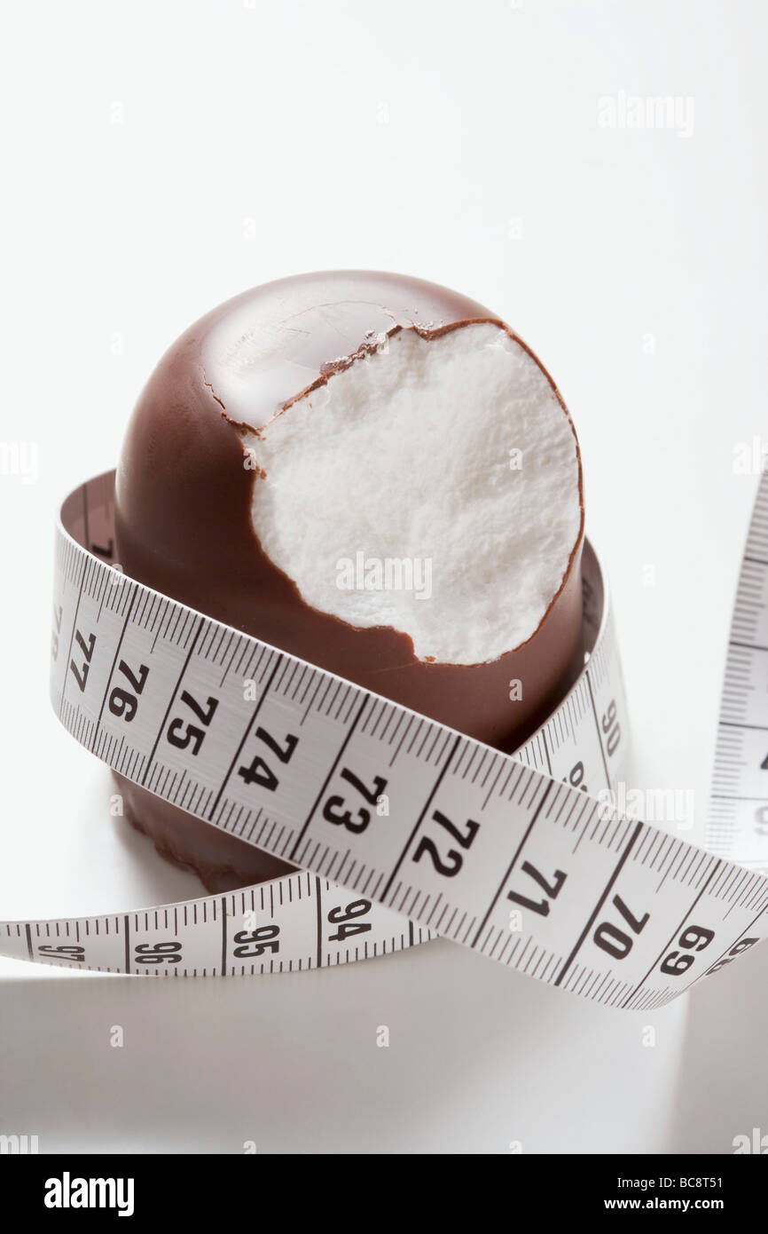 Chocolate-coated marshmallow treat with tape measure Stock Photo - Alamy