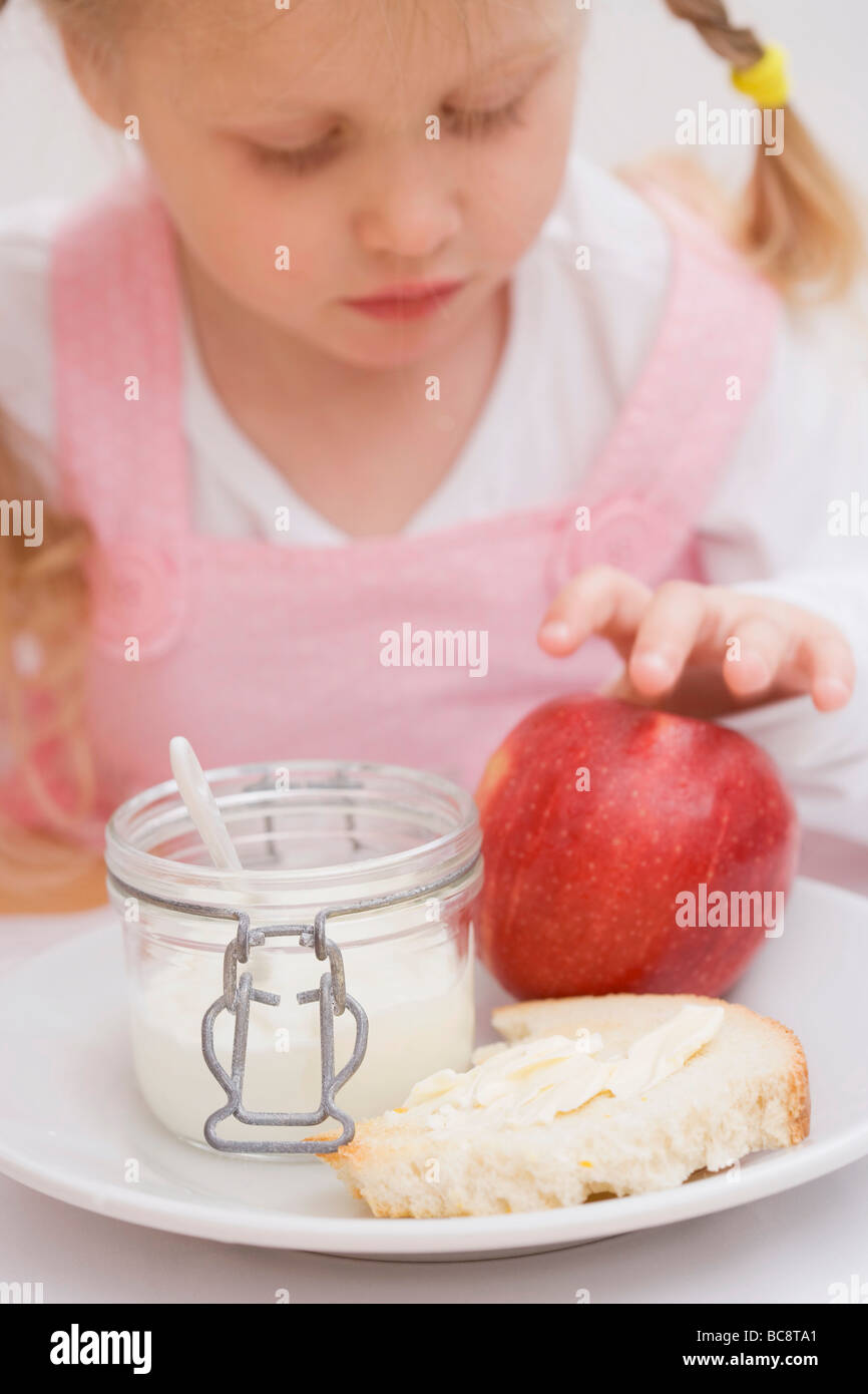 Little girl with apple, yoghurt and bread and butter Stock Photo - Alamy