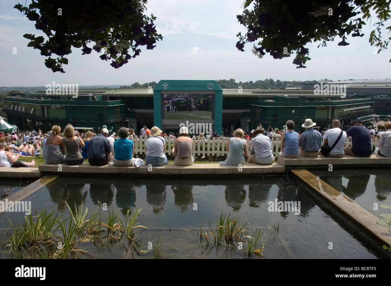 Female spectators watch the tennis on the big screen at Wimbledon Stock ...