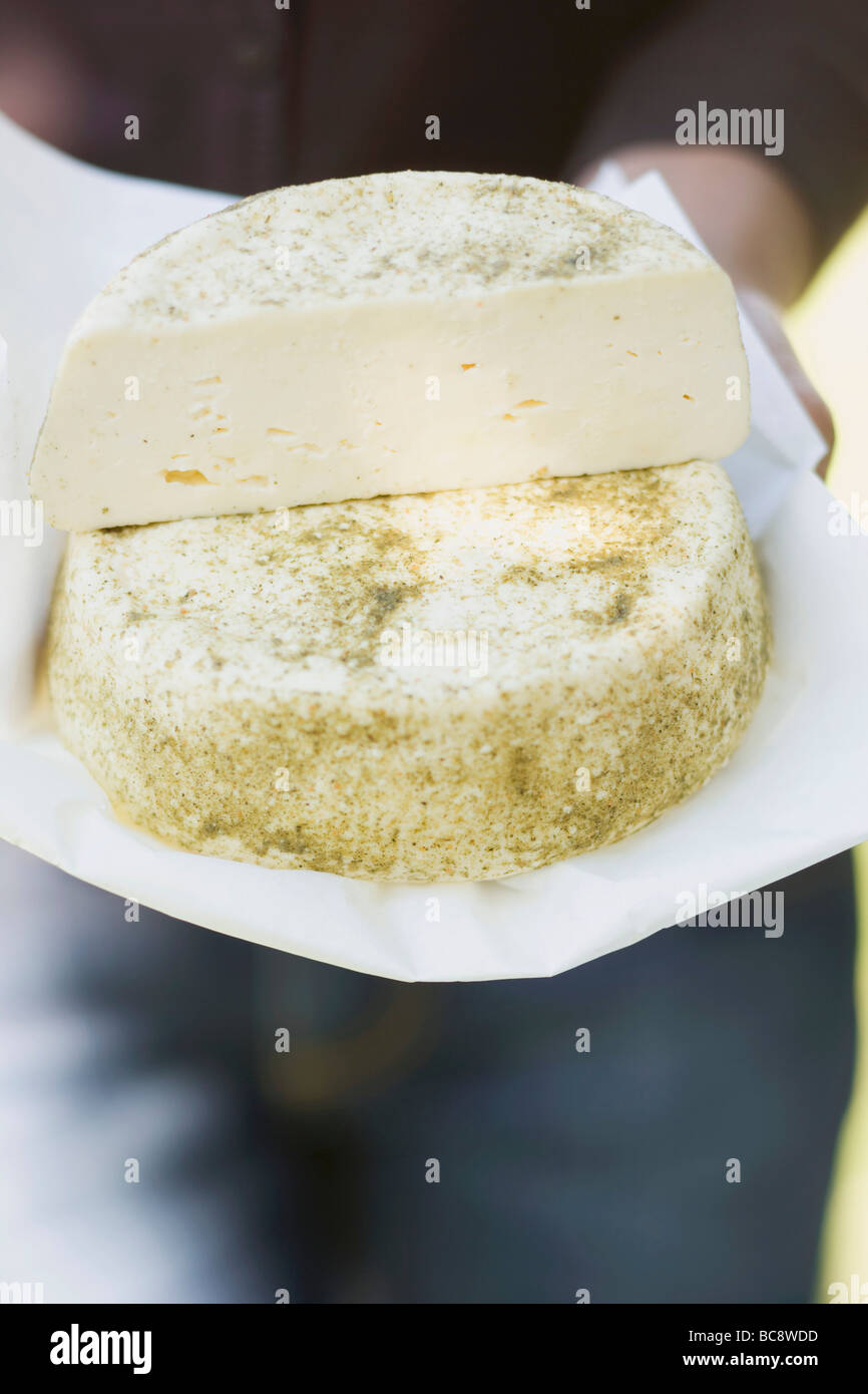 Person holding a whole cheese and half a cheese Stock Photo - Alamy