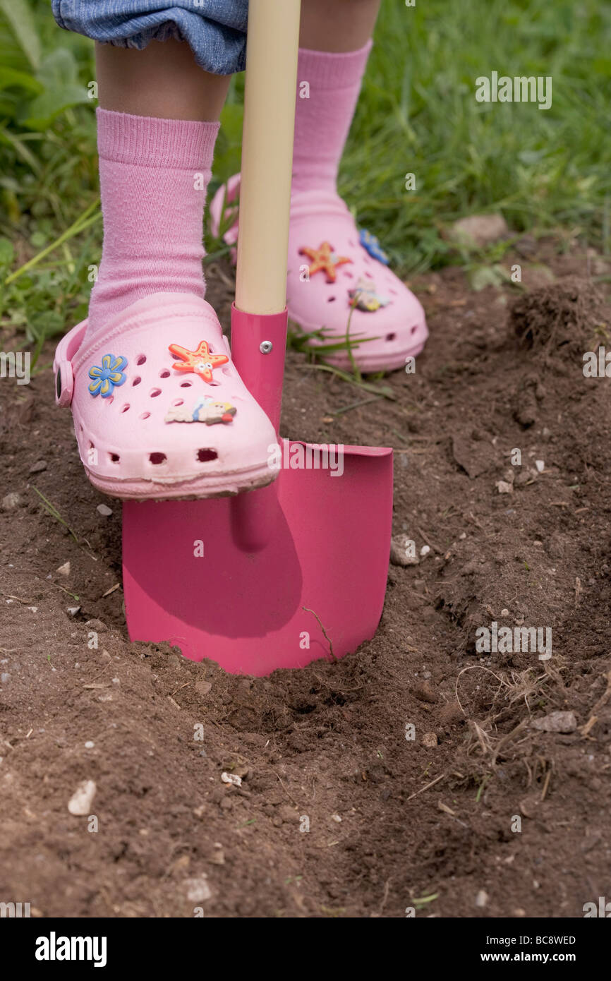 Little girl digging with a spade Stock Photo - Alamy