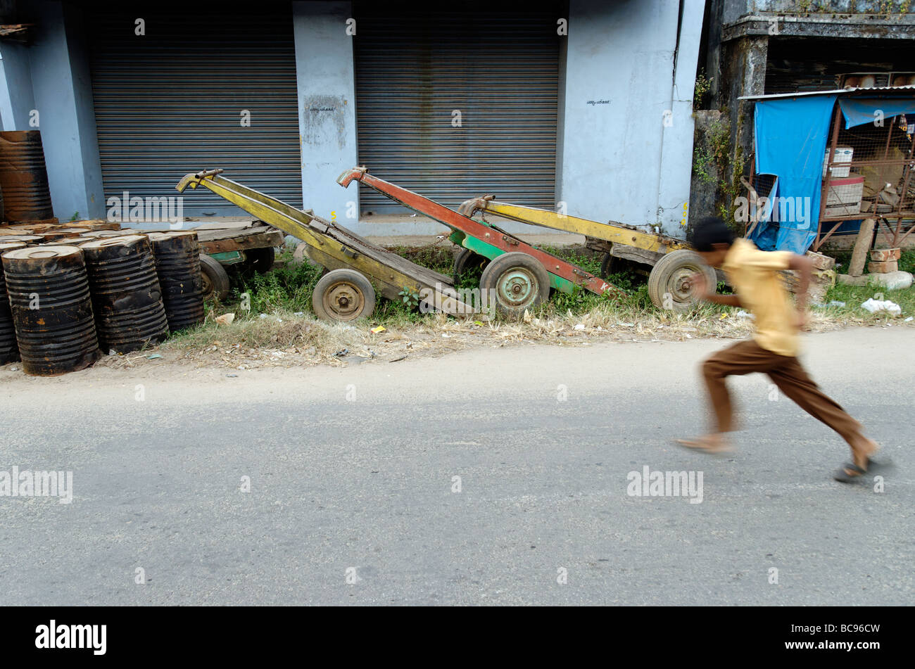 Young boy running down a street Stock Photo - Alamy