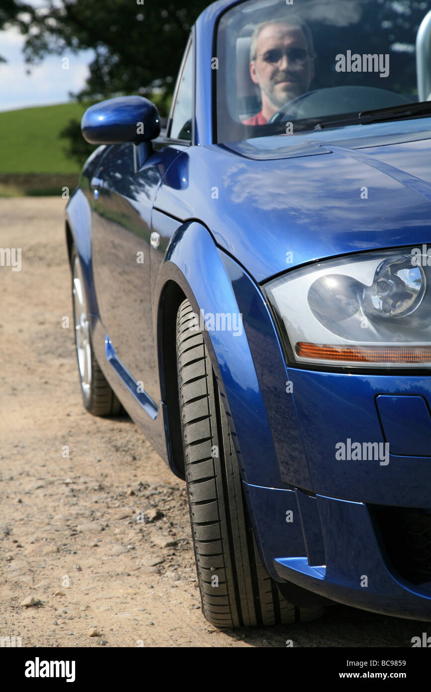 Man driving a blue Audi TT sportscar roadster in the countryside Stock ...