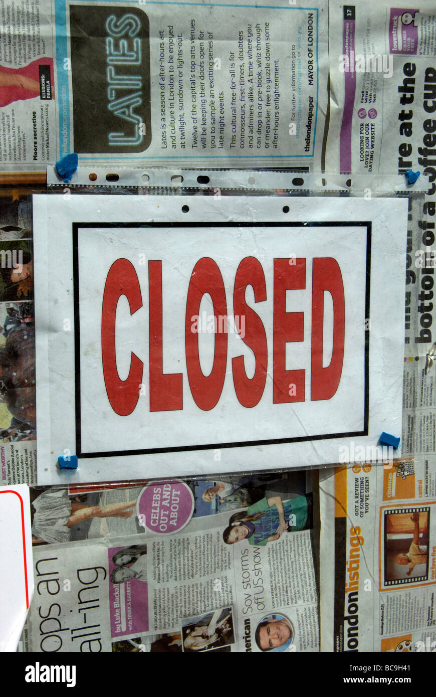 closed sign on a closed-down shop, its window filled with old ...
