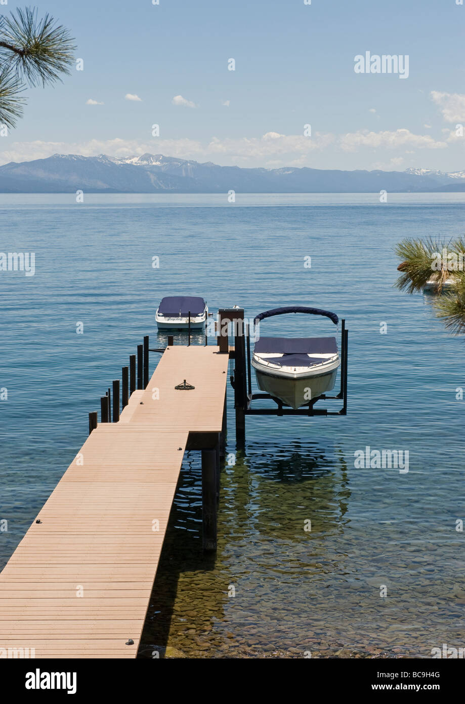 Open timber jetty projecting into tideless water from coast of the lake ...