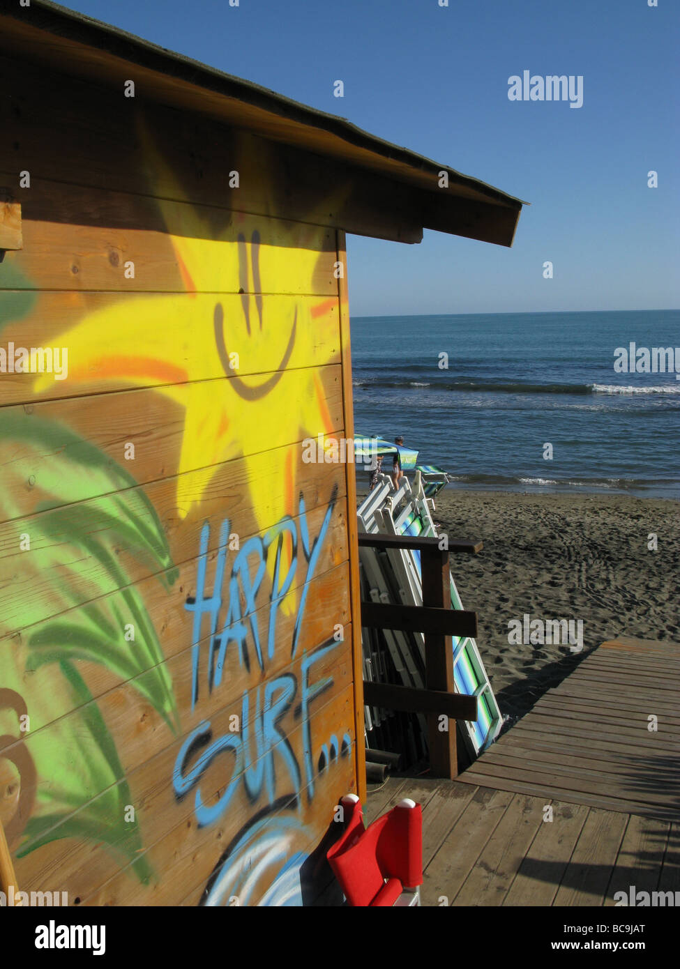 beach hut with happy smiling sun design by sea Stock Photo - Alamy