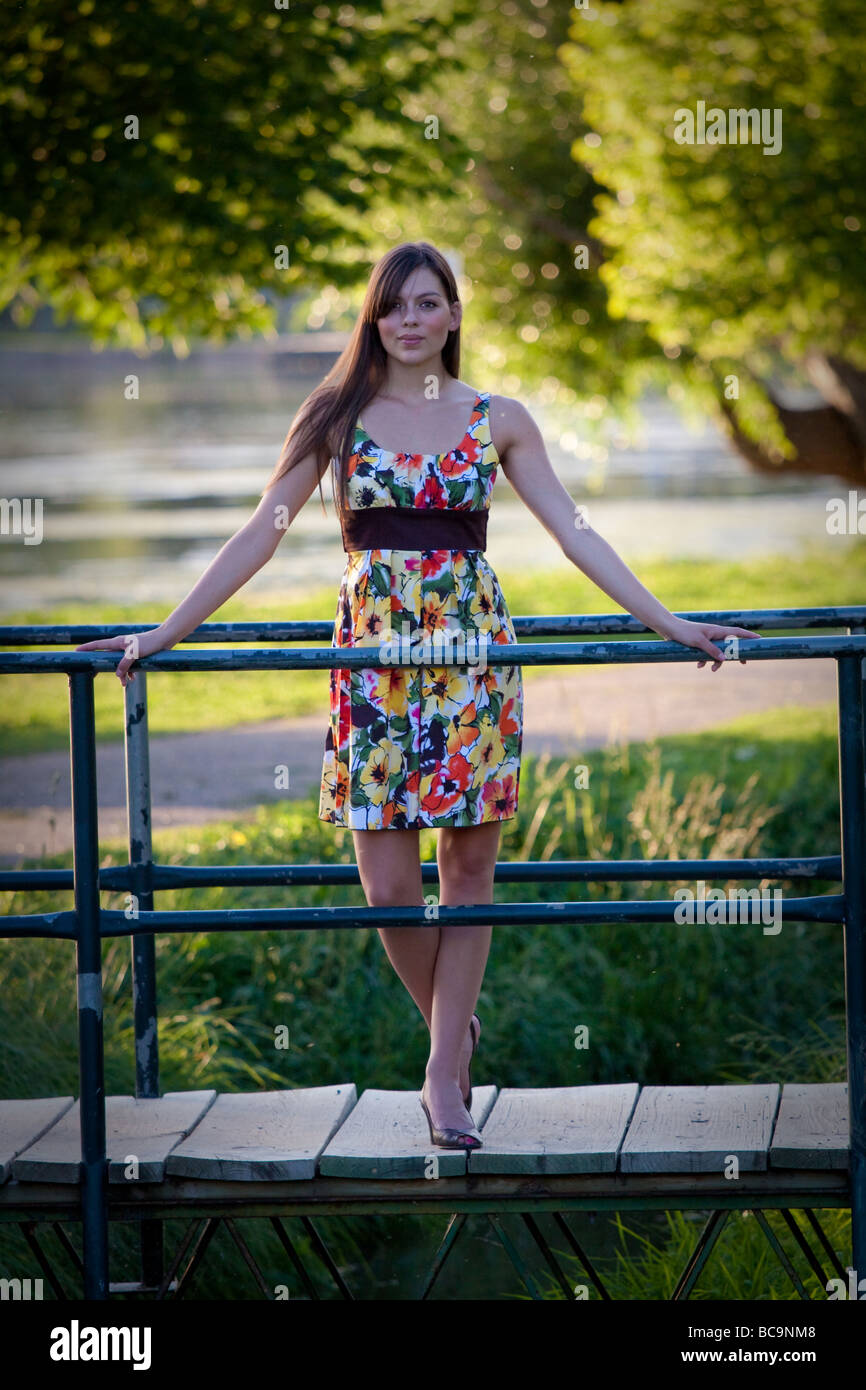 Girl wearing dress standing on a bridge Stock Photo - Alamy