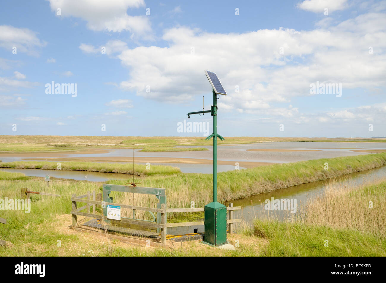 Grazing marsh showing sluice with solar powered water level monitoring ...