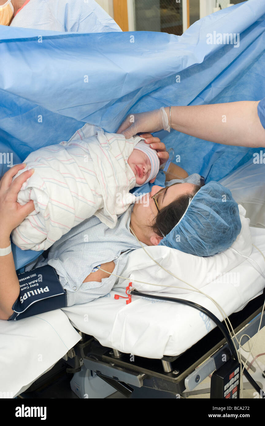 Hispanic mother in her thirties sees her newborn son for the first time ...
