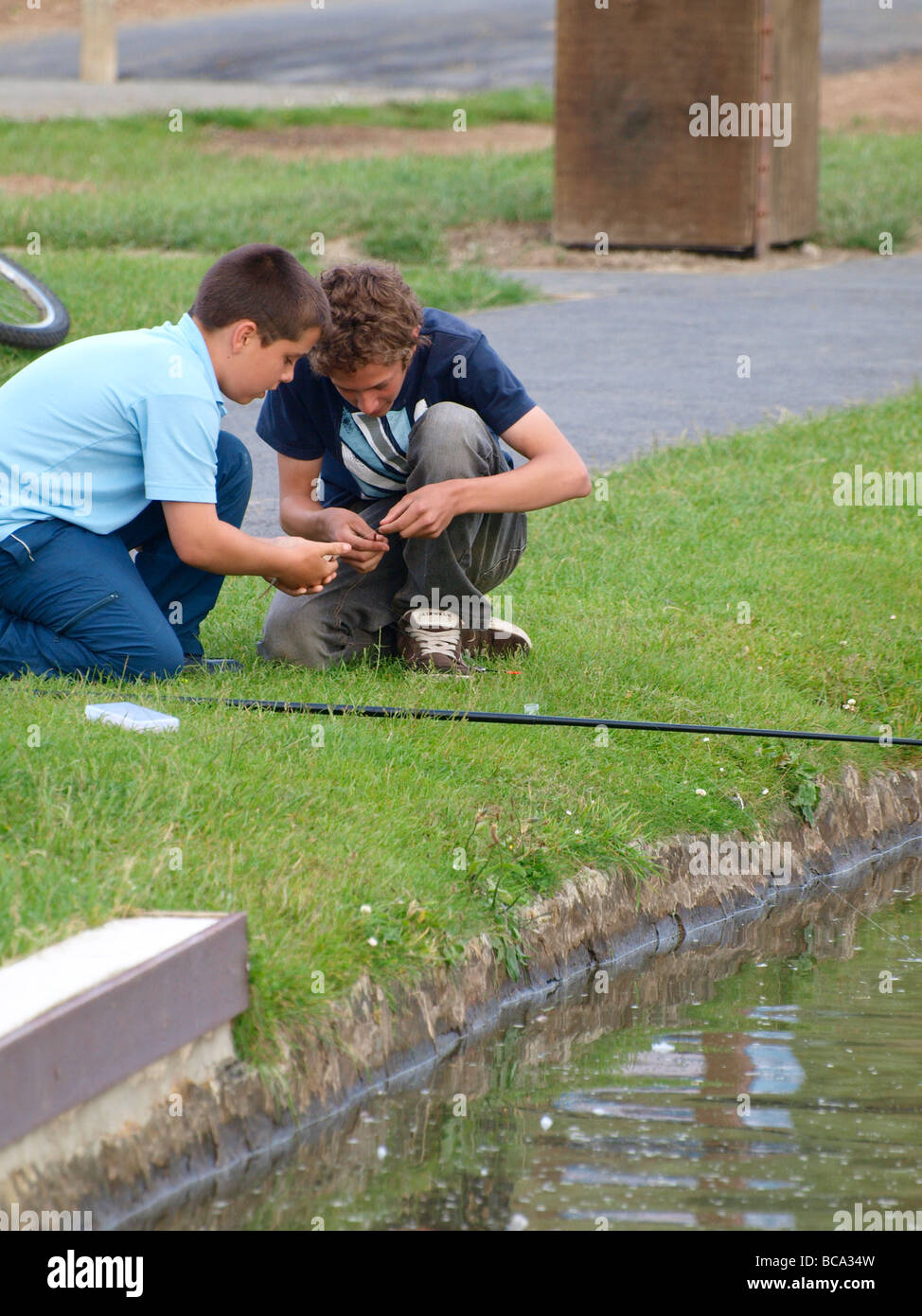 Two boys fishing Having caught a fish working together to take the hook ...