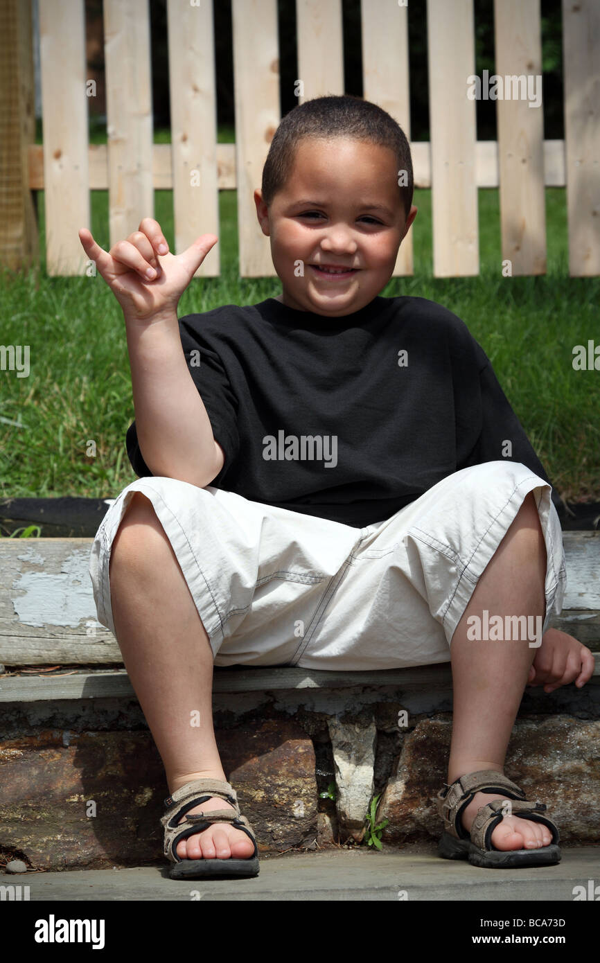 Latino boy giving hand signal Stock Photo - Alamy