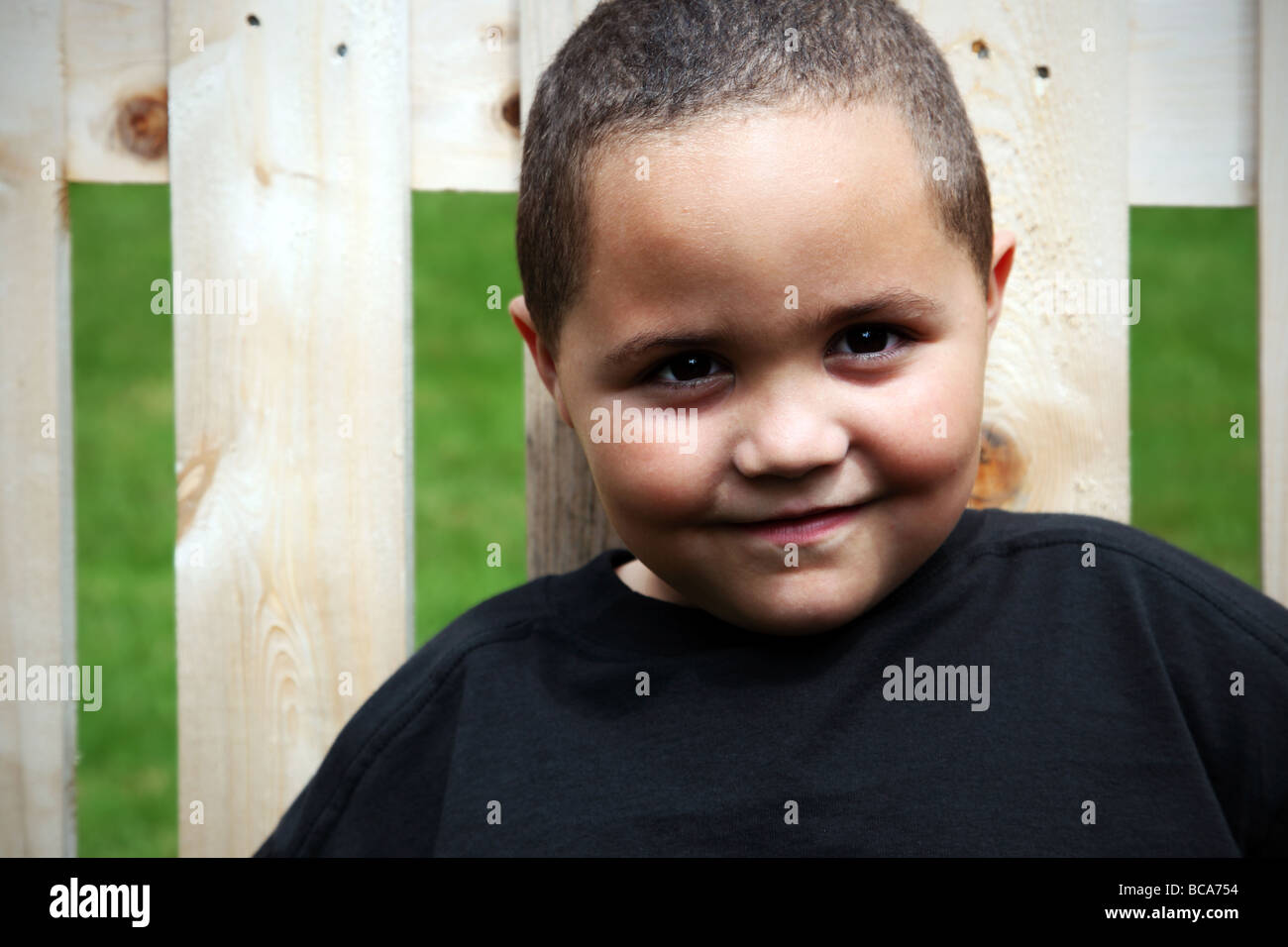 Boy leaning against fence hi-res stock photography and images - Alamy