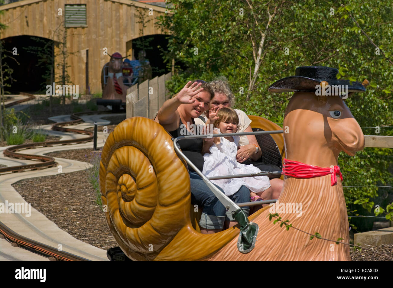 3 Generations Riding an Amusement Park Snail Ride Stock Photo - Alamy
