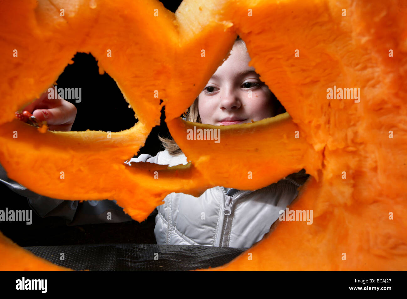 Girl carves a face into a pumpkin for Halloween Stock Photo - Alamy
