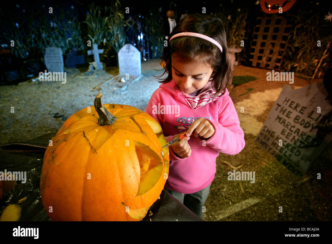 Girl carves a face into a pumpkin for Halloween Stock Photo - Alamy