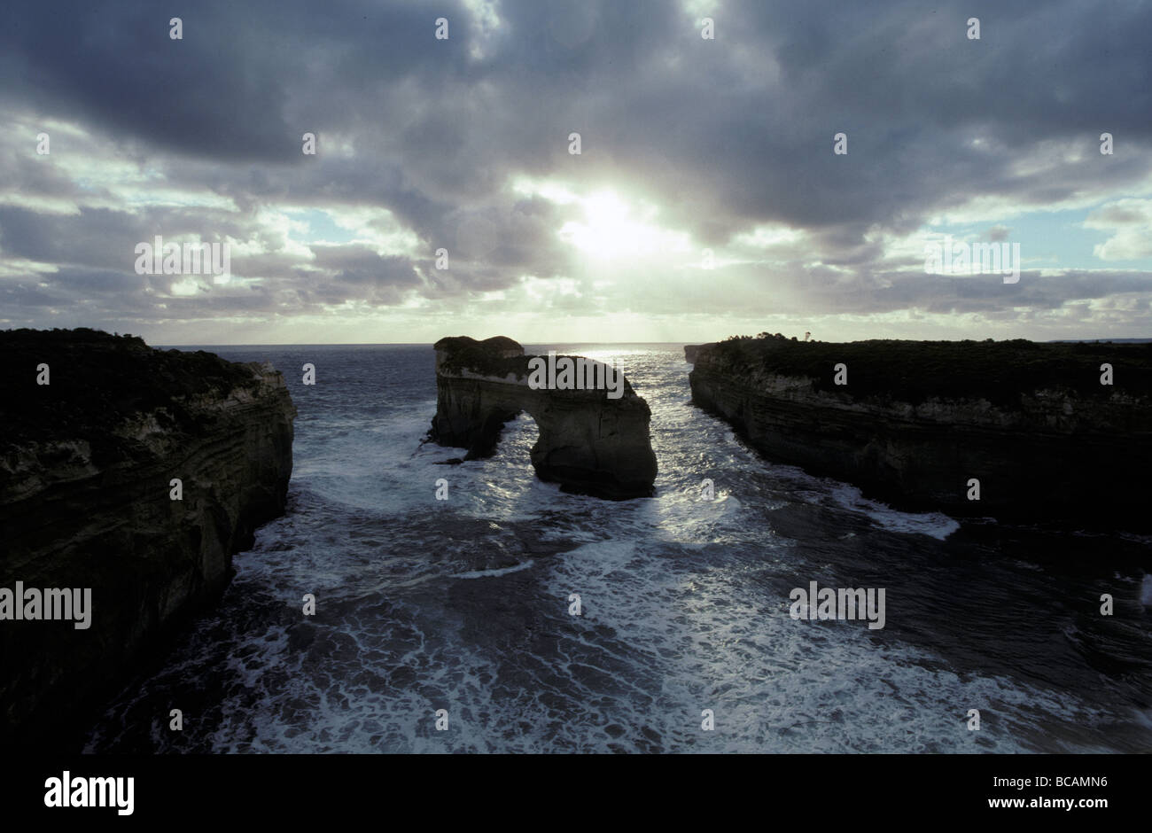 A sandstone arch formation created by coastal erosion at sunset Stock ...