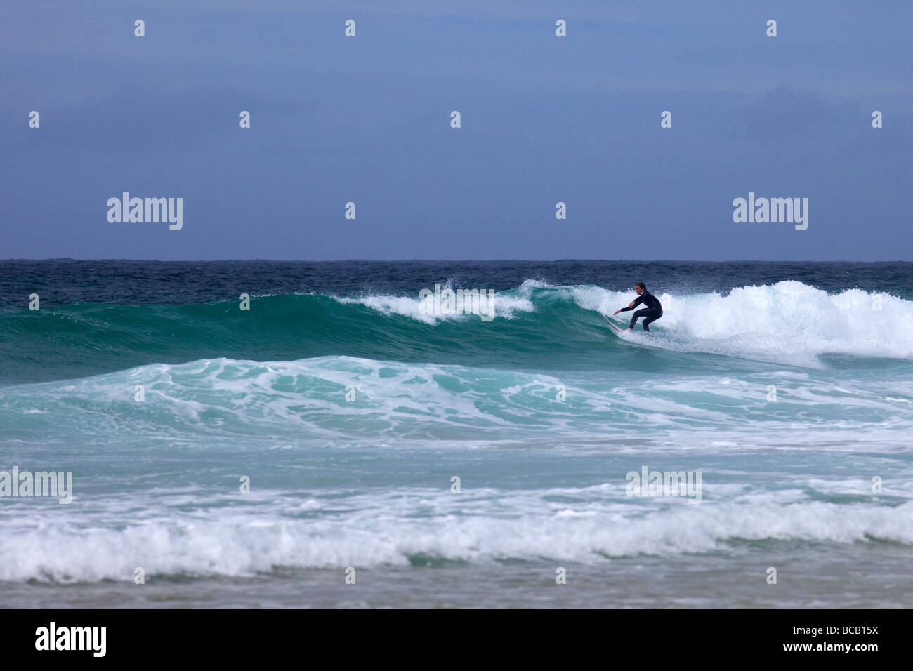 Surfing waves off Porthmeor beach in summer sun St Ives Cornwall ...