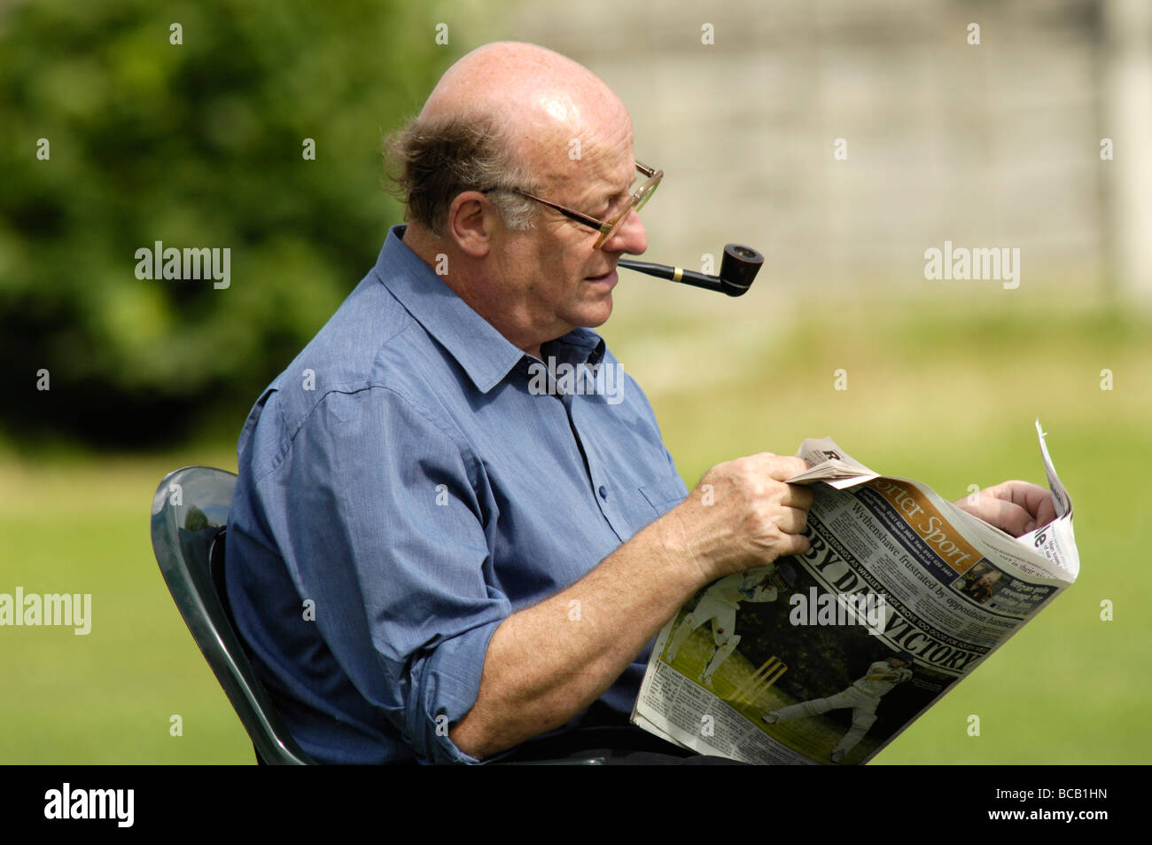 Man smoking pipe reading newspaper hi-res stock photography and images ...