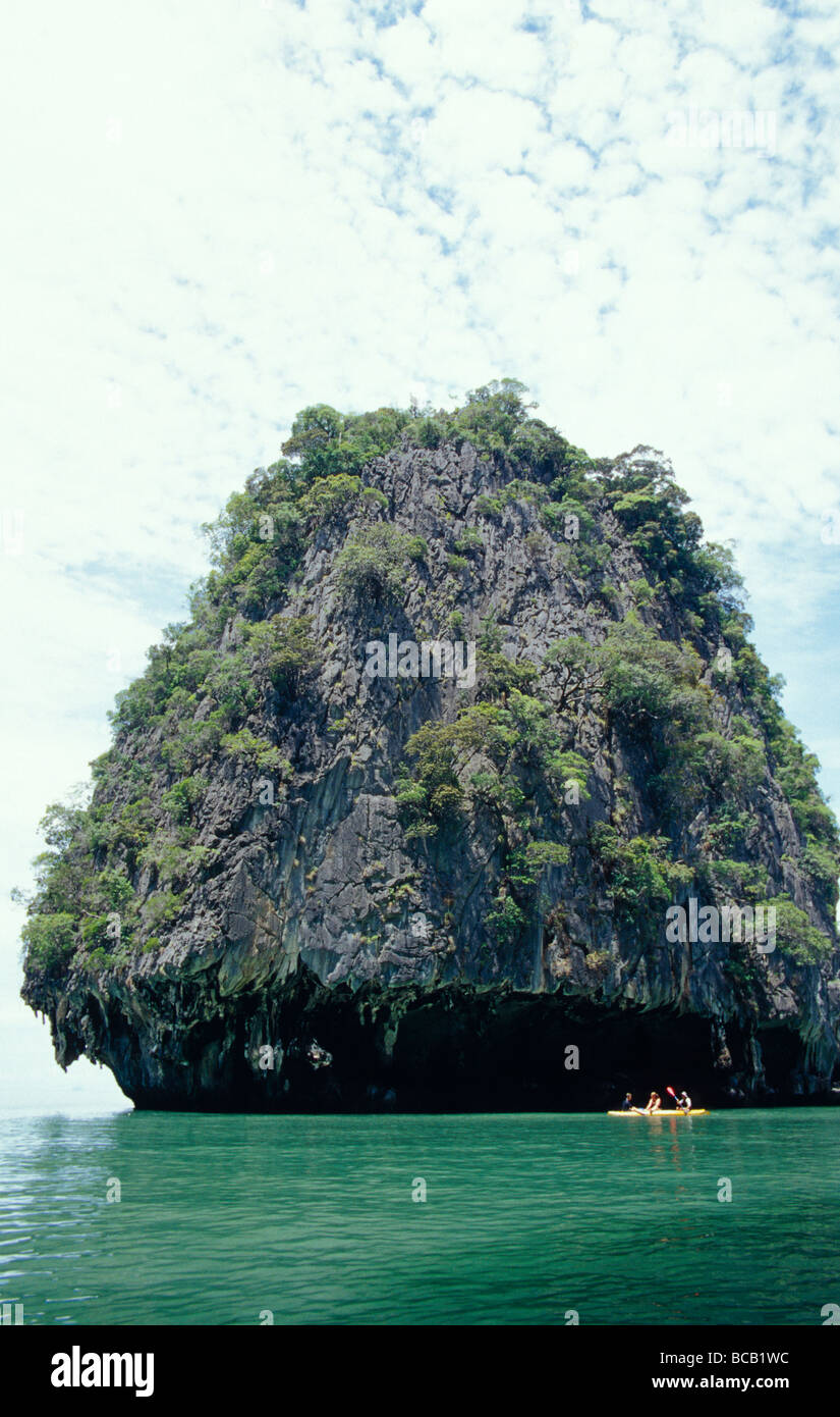 Tourists in canoes explore rainforest covered limestone islands Stock ...