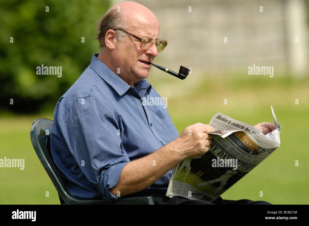 Man smoking pipe reading newspaper hi-res stock photography and images ...