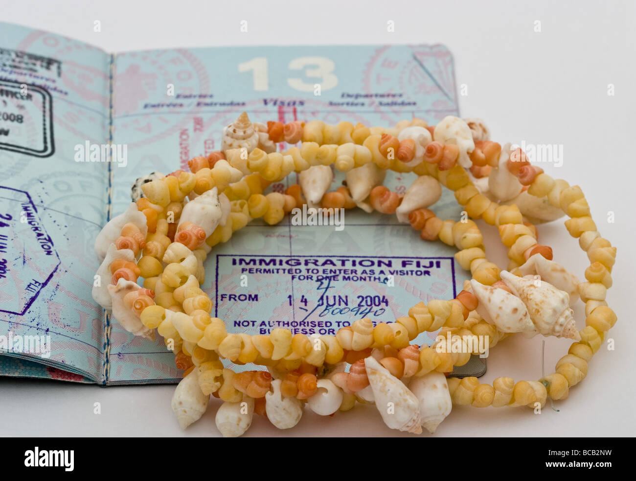 Shell necklace atop a passport with a stamp for Fiji Stock Photo - Alamy