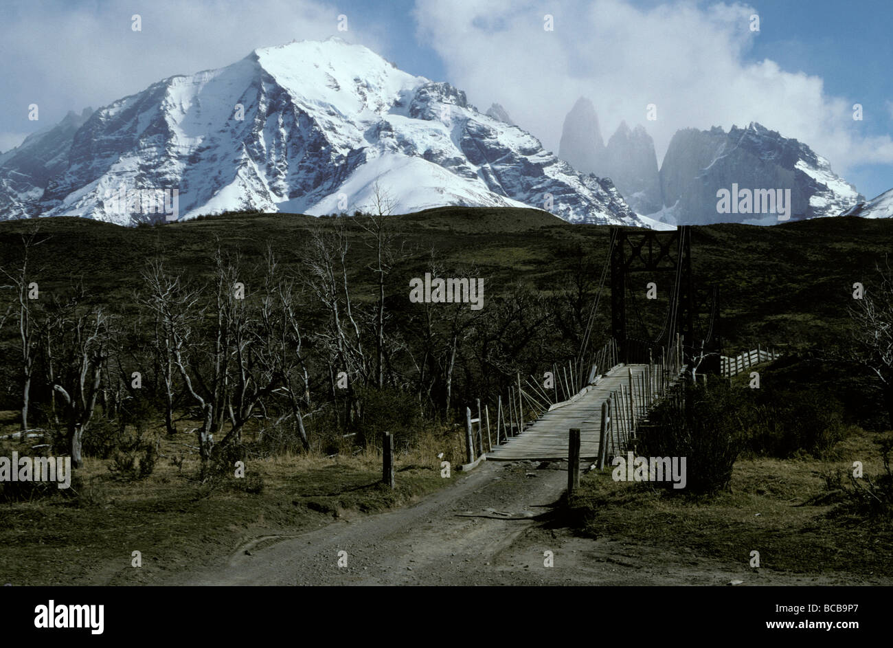 A remote wooden bridge in the icy wilderness of the Andes Mountains ...