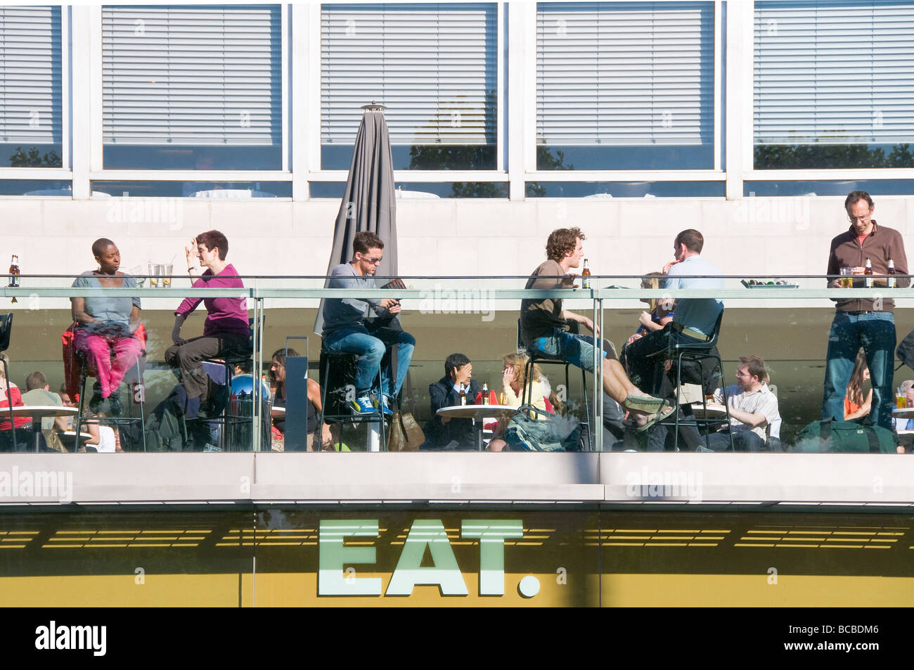 People eating and drinking on the outdoor patio of a London restaurant ...