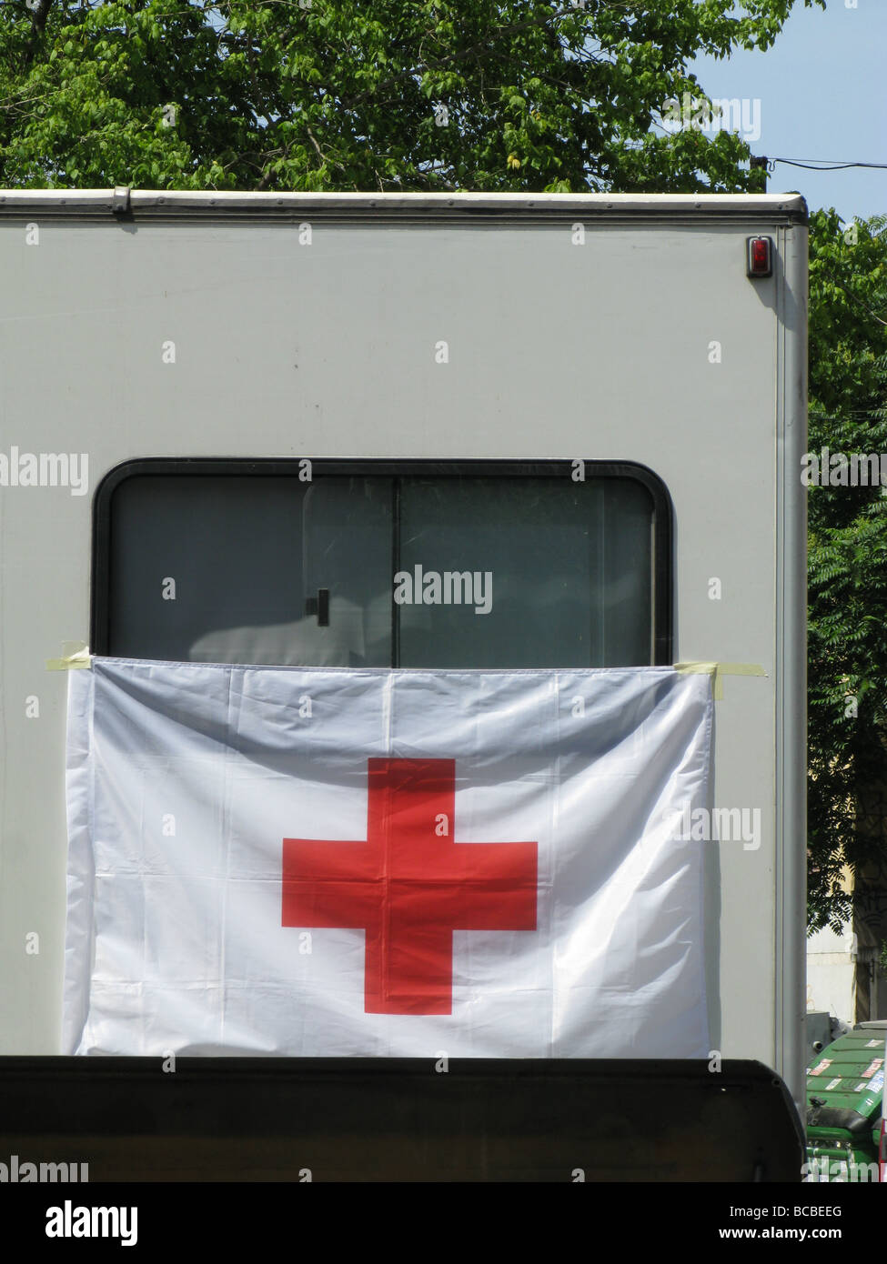 red cross flag on vehicle in street in sun Stock Photo - Alamy