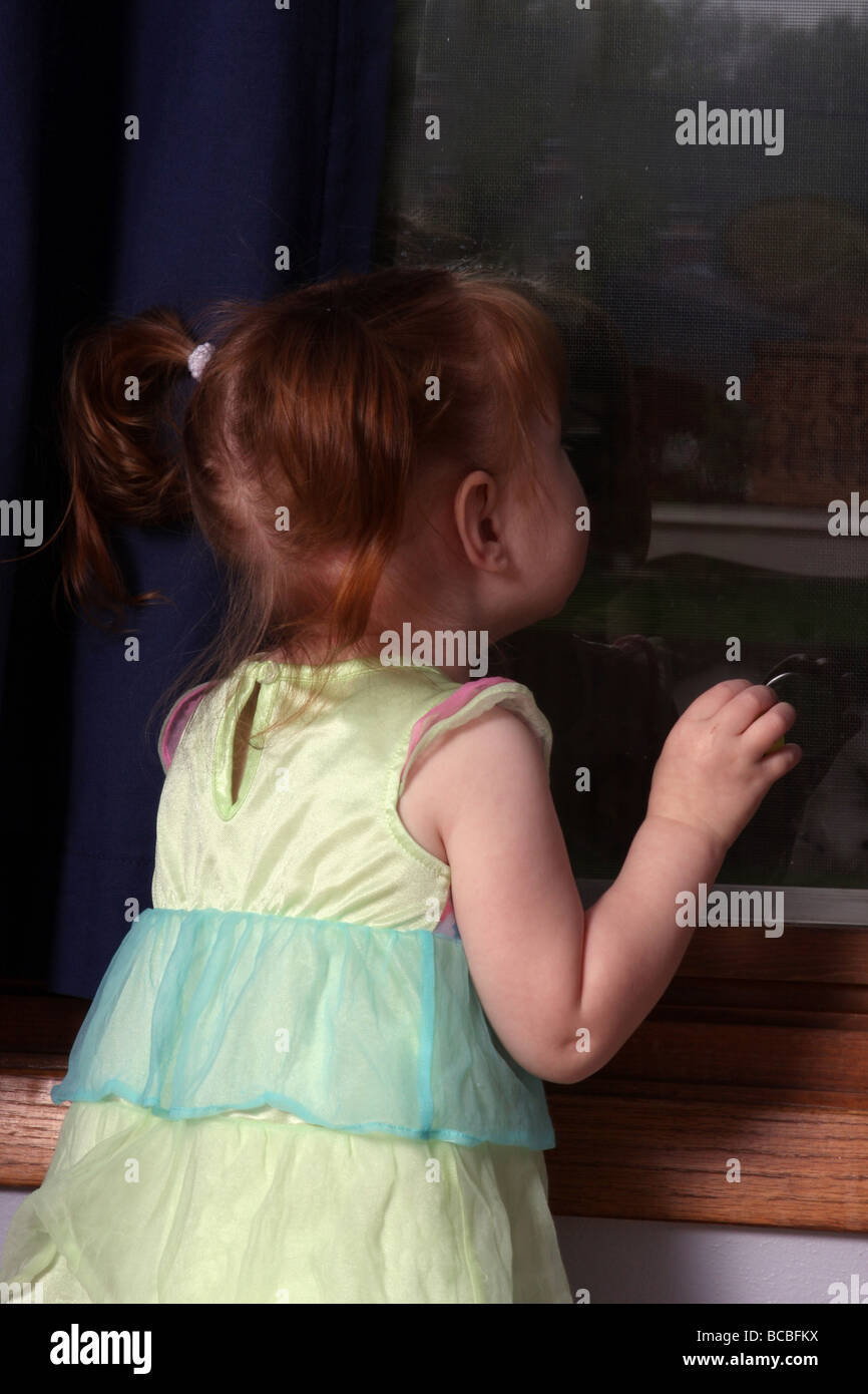 A young girl peeking out her bedroom window at night Stock Photo - Alamy