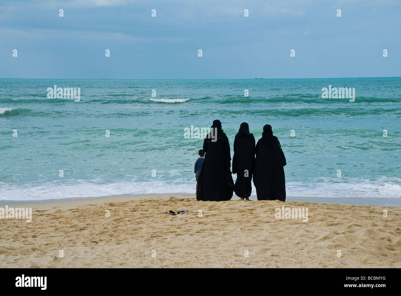 Three arabic women standing on the beach, staring at horizon Stock ...