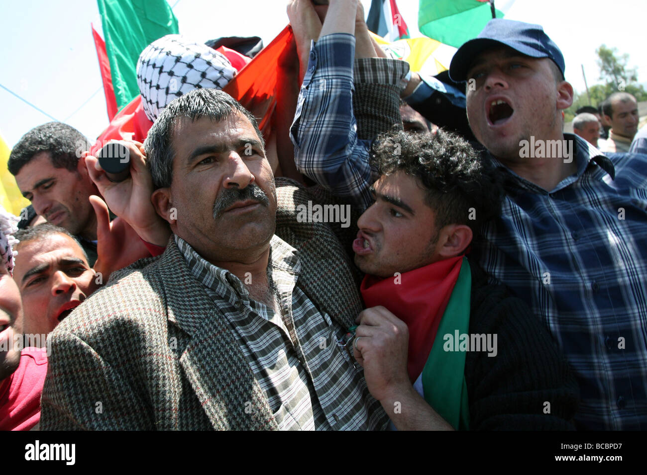 Palestinian men carrying a body at a funeral in the West Bank village ...