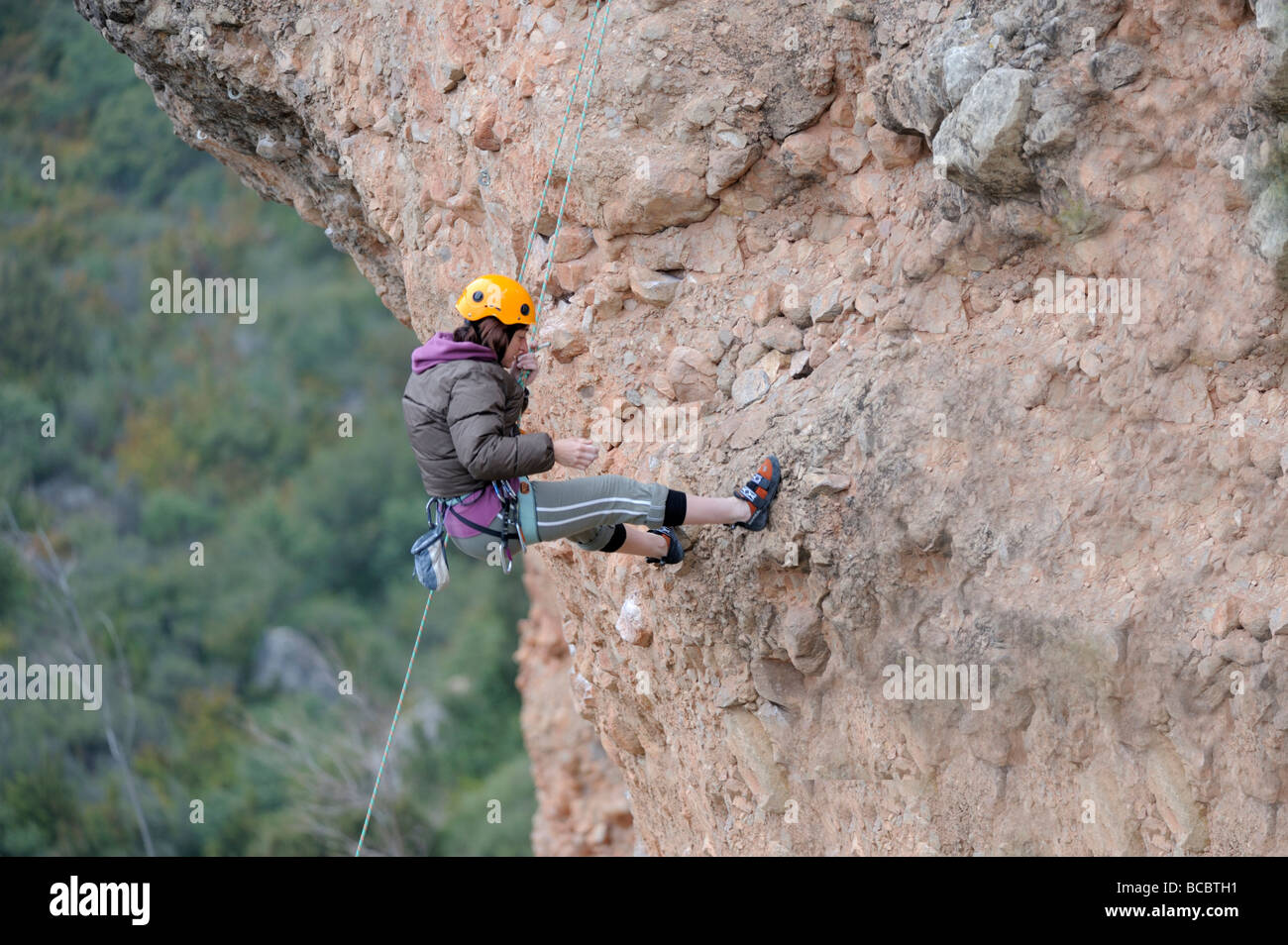 Woman climbing rock face Stock Photo - Alamy