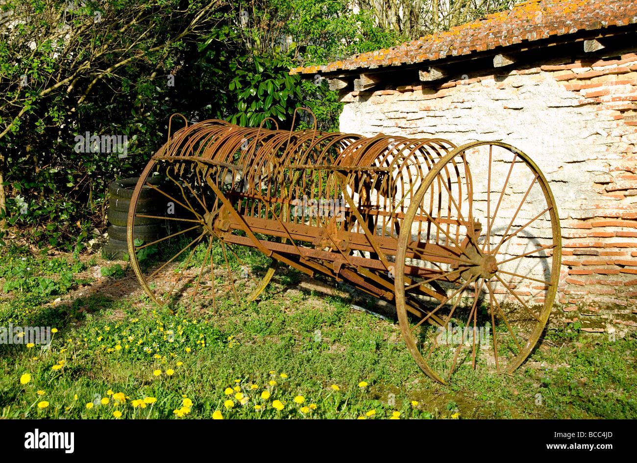 a rusty old farm rake by a barn in France Stock Photo - Alamy