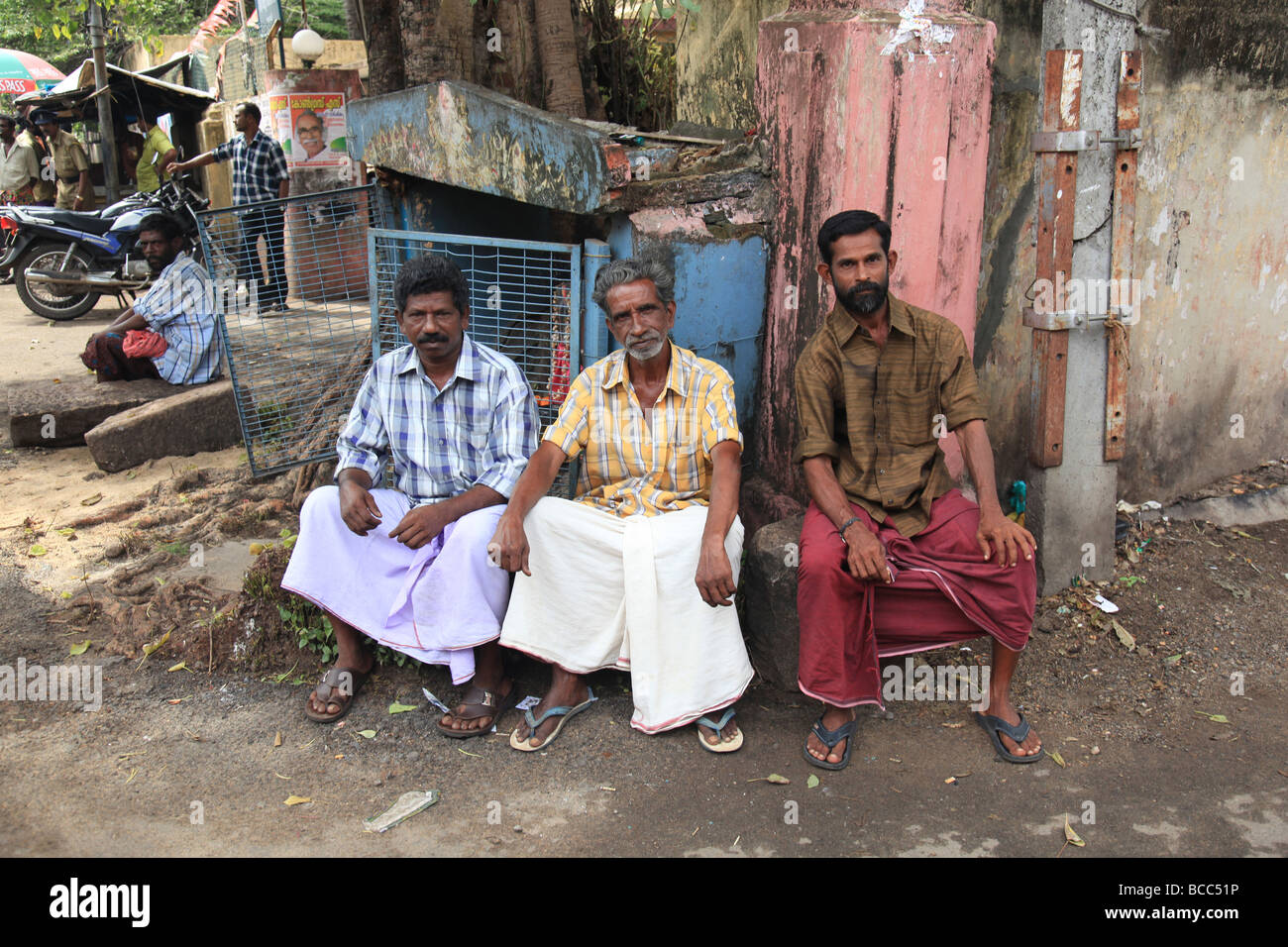 Three Indian men sitting outside a roadside shrine, Kerala, India Stock ...