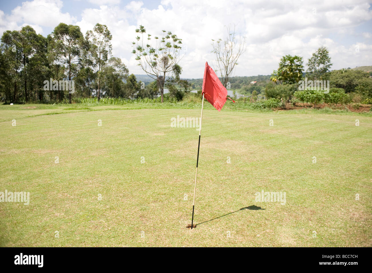 Jinja golf course green and hole with red flag Stock Photo - Alamy