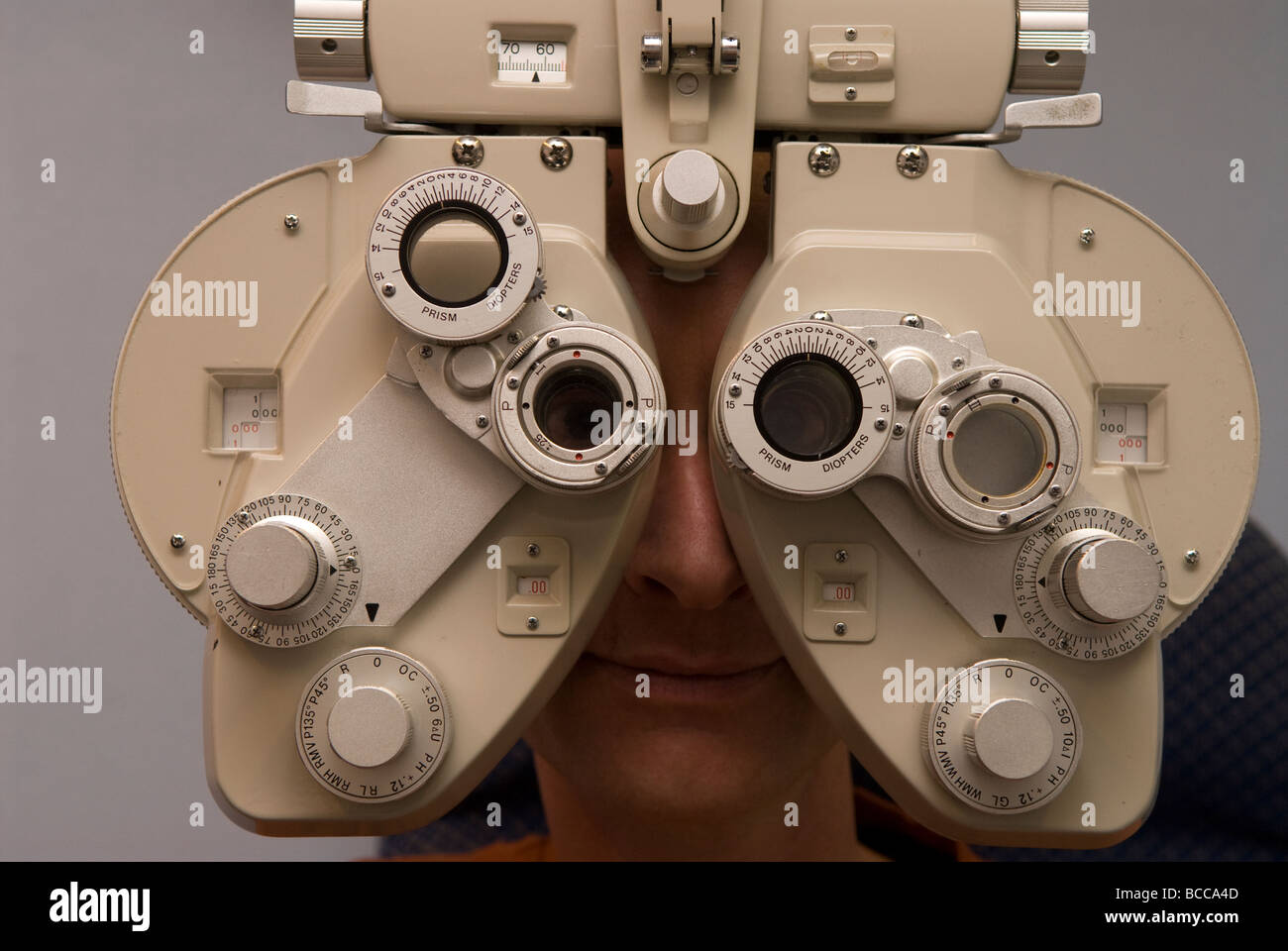 Man having eye test at opticians using Phoropter Head equipment ...